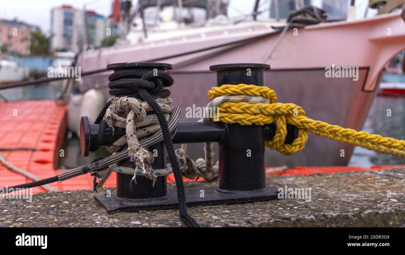 Close-up of two ship mooring cables tied to the pier, holding the ship ...