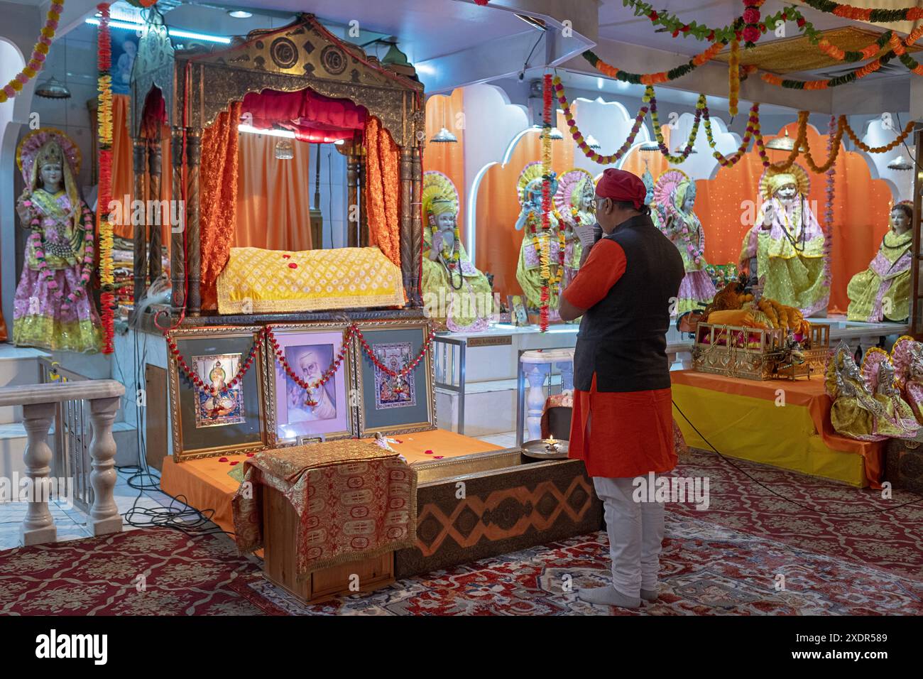 A Hindu priest reads personal messages at a service in the Satya ...