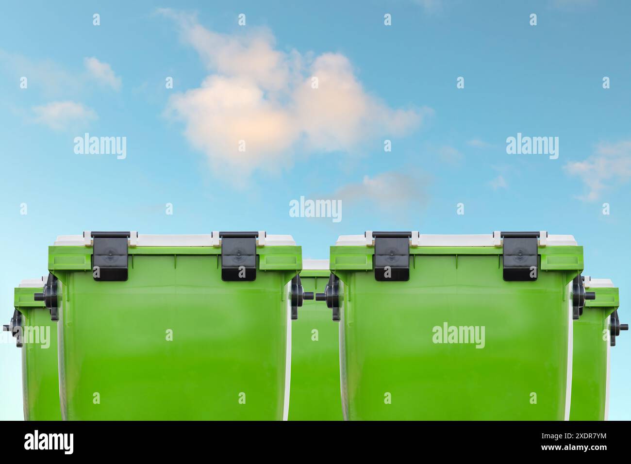 Large new green waste containers in front of a blue sky Stock Photo - Alamy