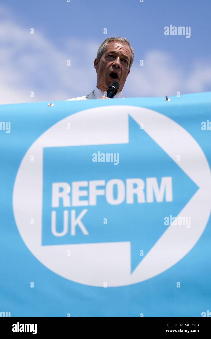 Reform UK leader Nigel Farage speaking on top of a double decker bus at ...