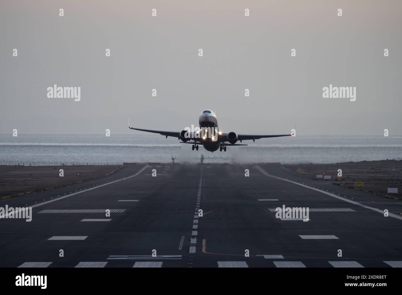 Airplane taking off from runway at dusk Stock Photo - Alamy