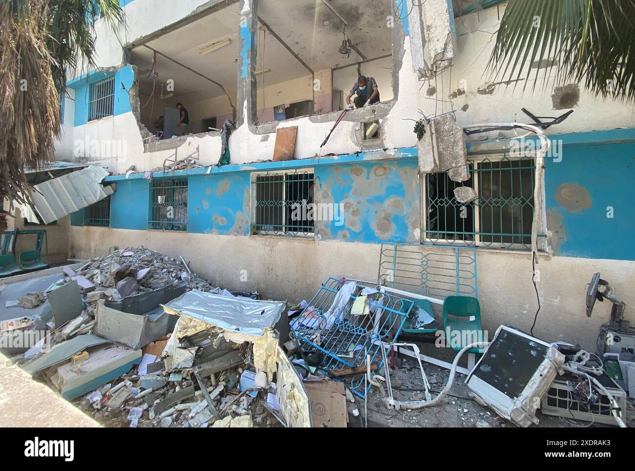 Palestinians inspect the rubble at the al-Daraj clinic in Gaza City ...
