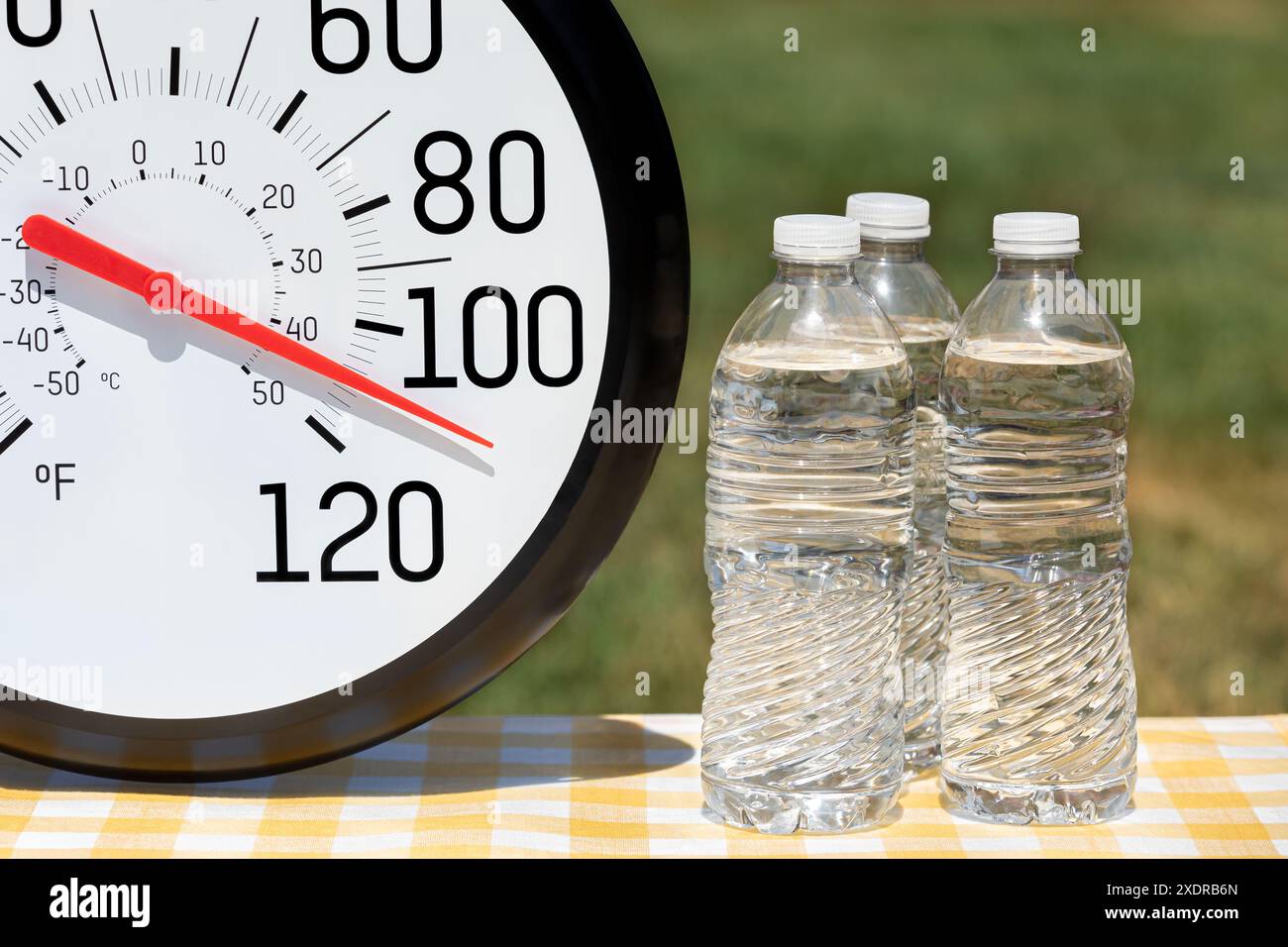 Outdoor thermometer with water bottles in the sun during heatwave. Hot ...