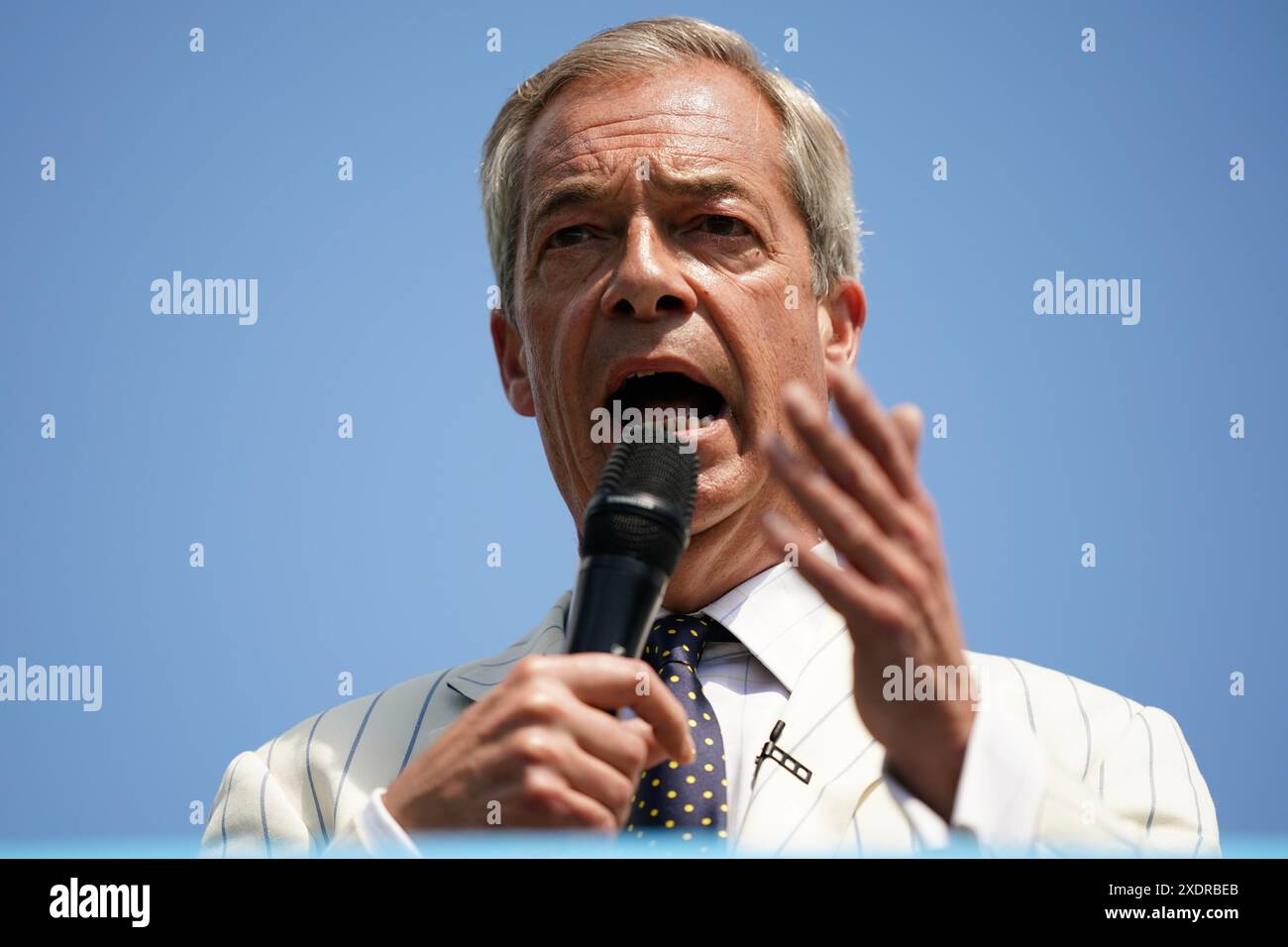 Reform UK leader Nigel Farage speaking on top of a double decker bus at ...