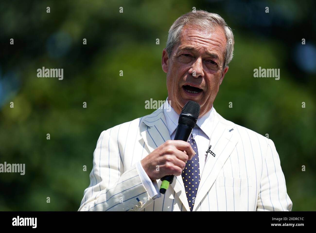 Reform UK leader Nigel Farage speaking on top of a double decker bus at ...
