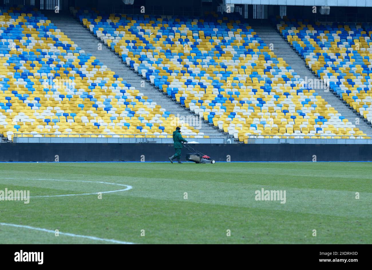 Worker mowing lawn on football field using grass-cutter Stock Photo - Alamy