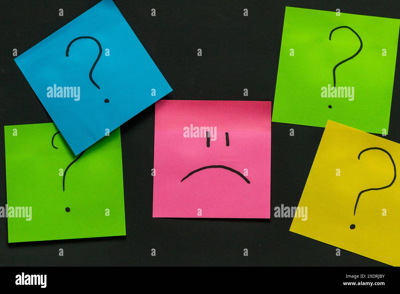 upset emoji surrounded by question marks on a dark background, failed ...