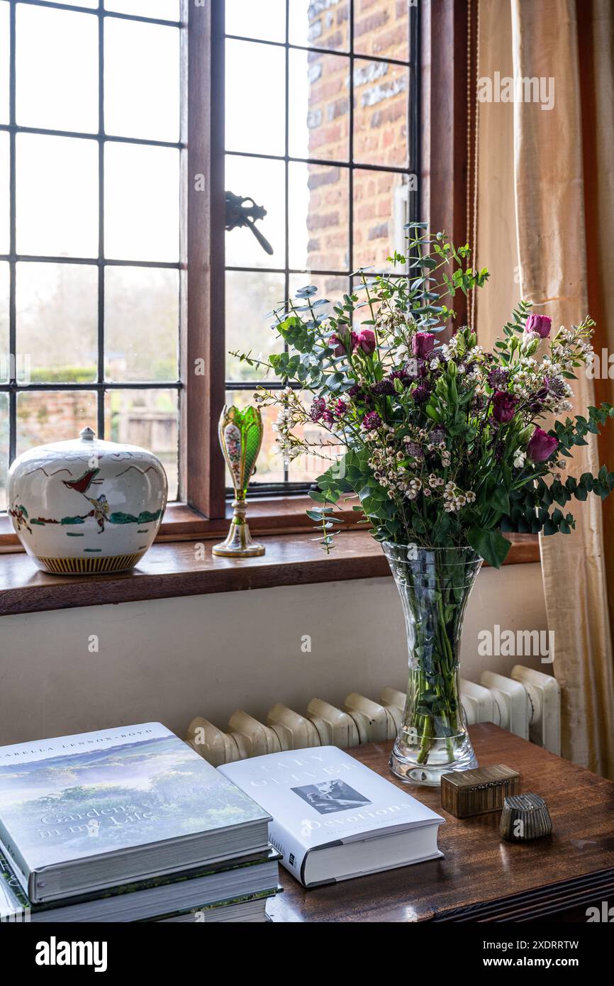 Rose bouquet and books in leaded glass window of 16th century Tudor ...