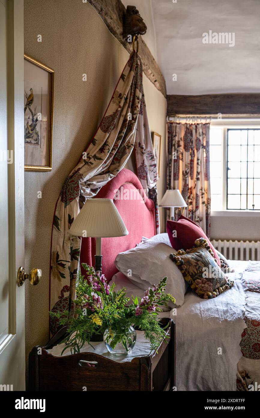 Tray-topped William IV cabinet with vintage fabrics in bedroom of 16th century Tudor farmhouse ...