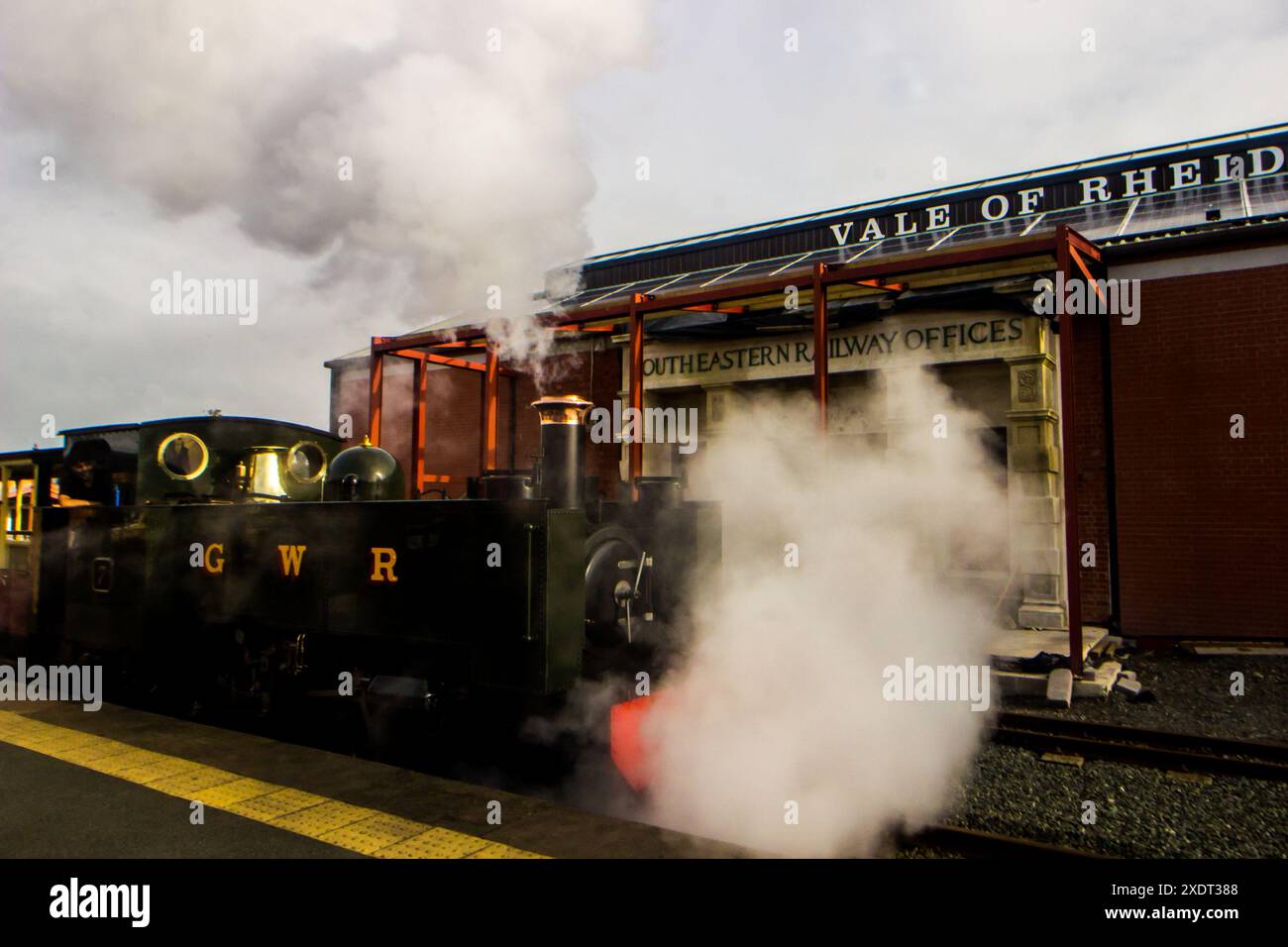 The vintage steam locomotive enveloped in a cloud of steam, arriving at ...