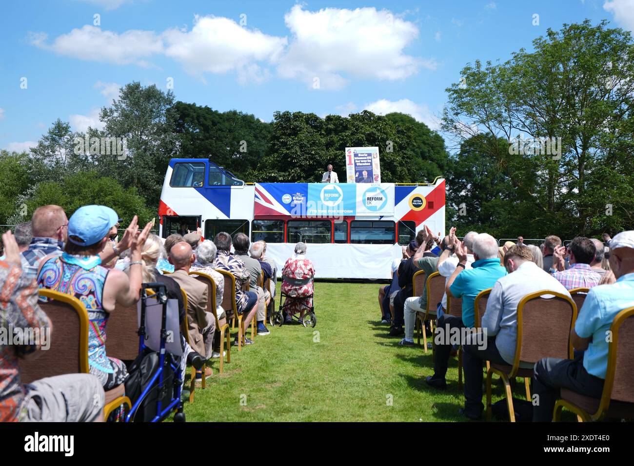 Reform UK leader Nigel Farage speaking on top of a double decker bus at ...