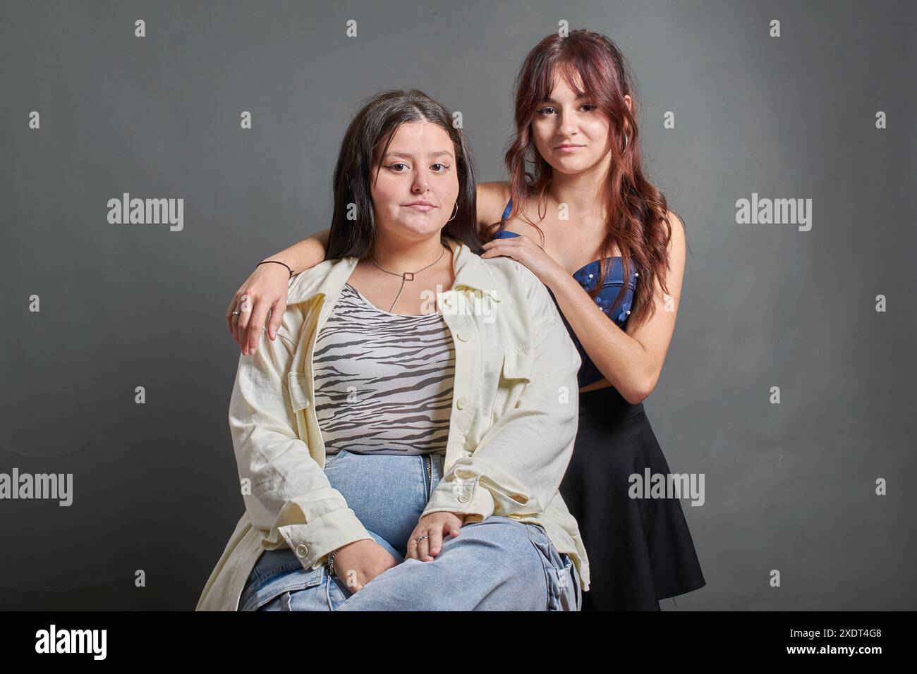 Two Hispanic friends posing in front of the camera, a relationship of ...
