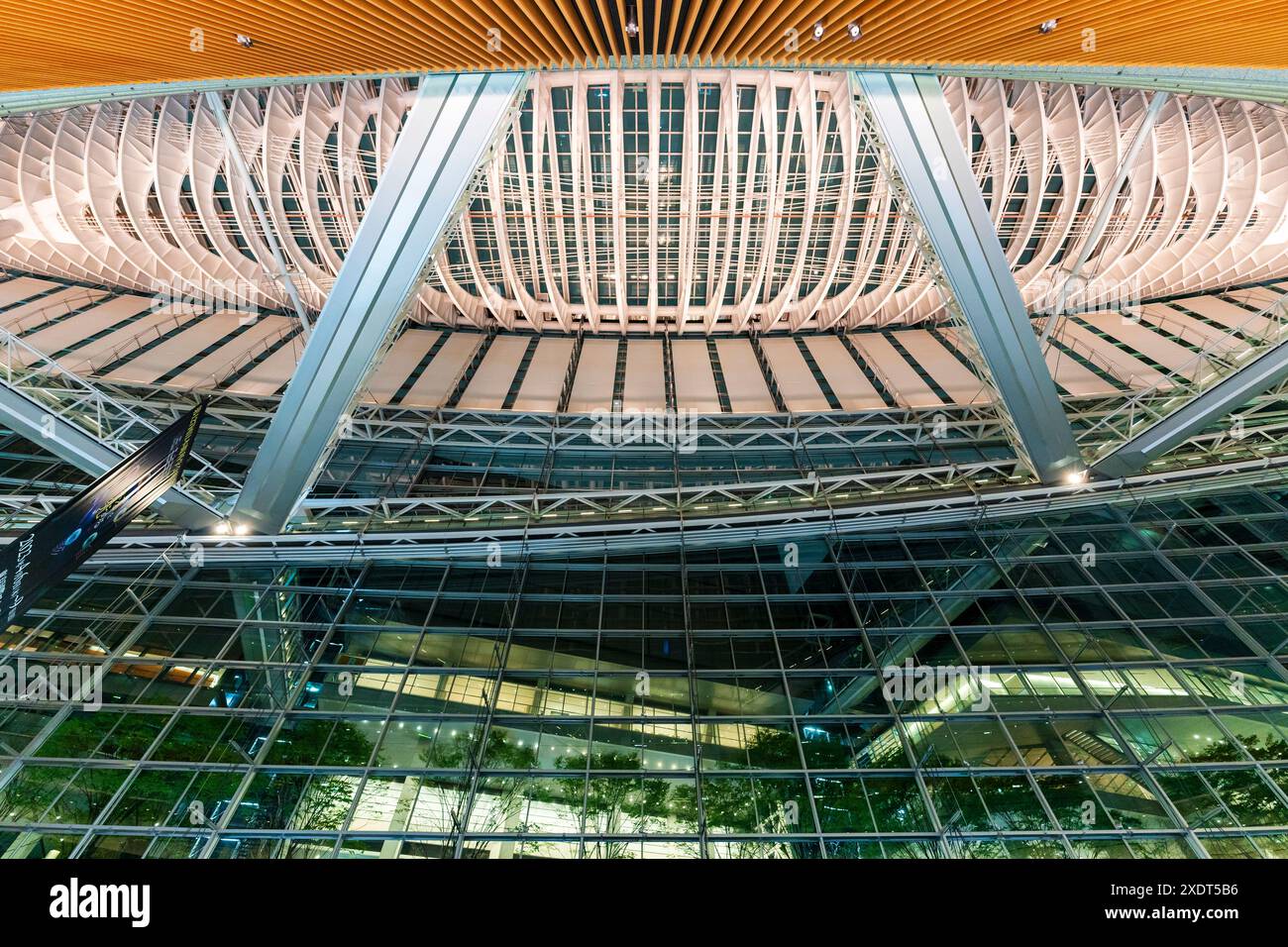 Interior, Tokyo International Forum building at night. View straight up ...