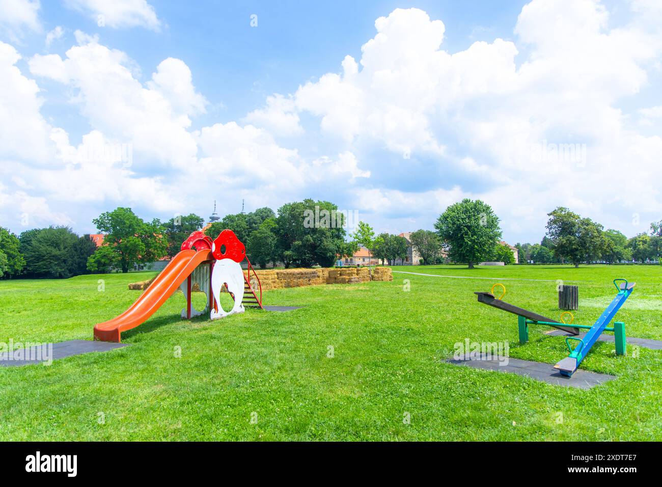 This image shows a red and blue playground equipment set on a large ...
