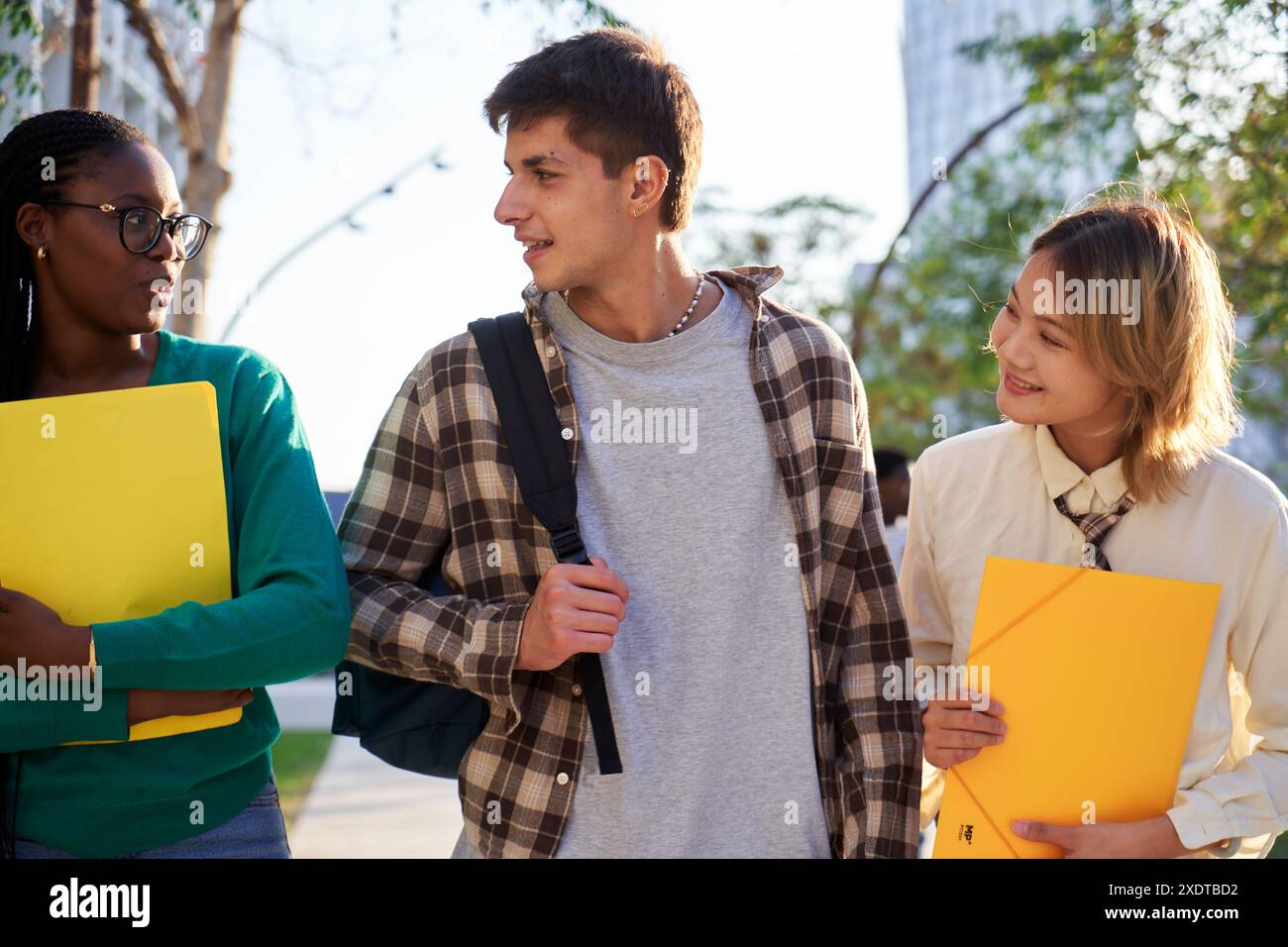 Three multiethnic student friends walking going to classroom at ...