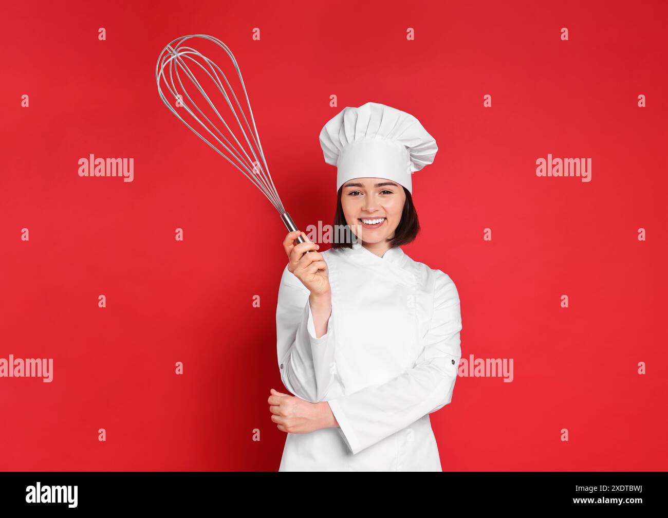 Happy pastry chef with big whisk on red background Stock Photo - Alamy