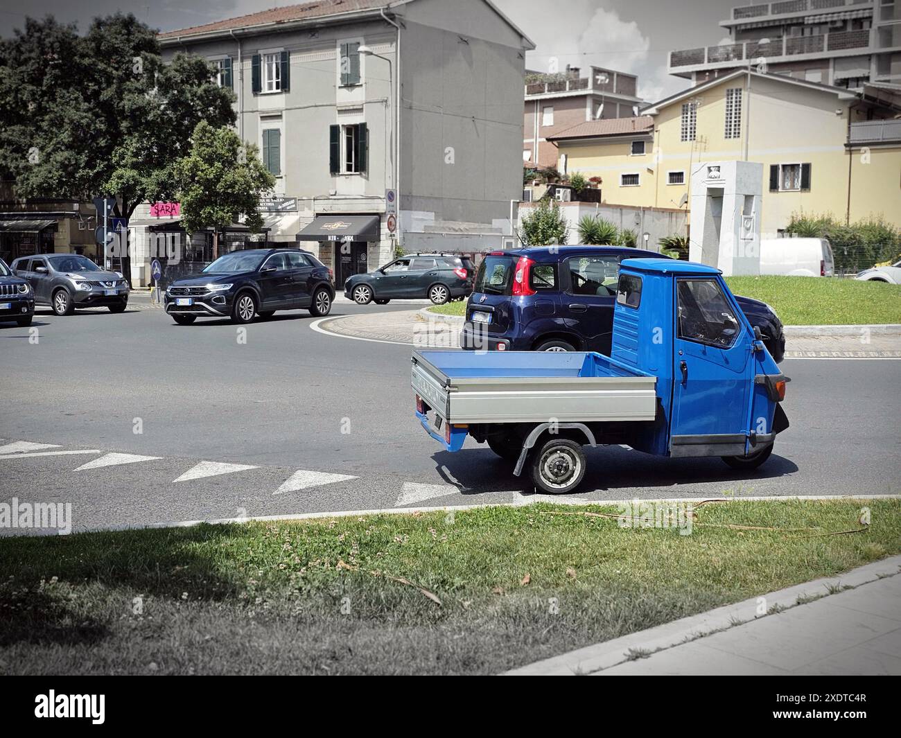 Random street view from Carrara, Italy. Cars in roundabout. Three wheel ...