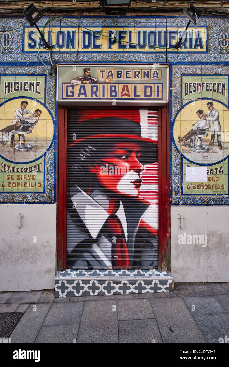 External view of an old barber shop in Madrid with a modern graffiti ...