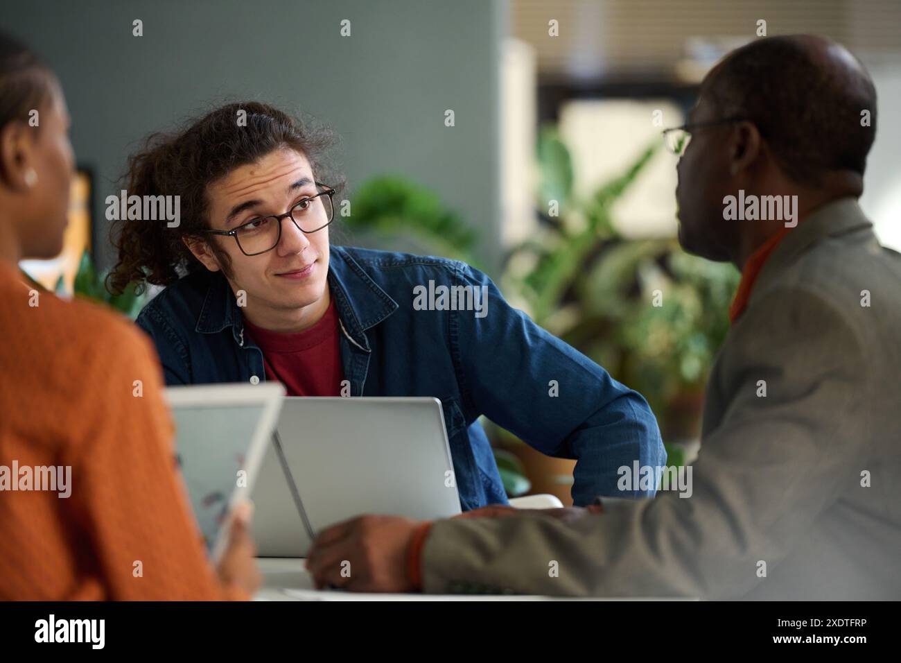 Portrait of gen Z young man collaborating with senior colleague in ...