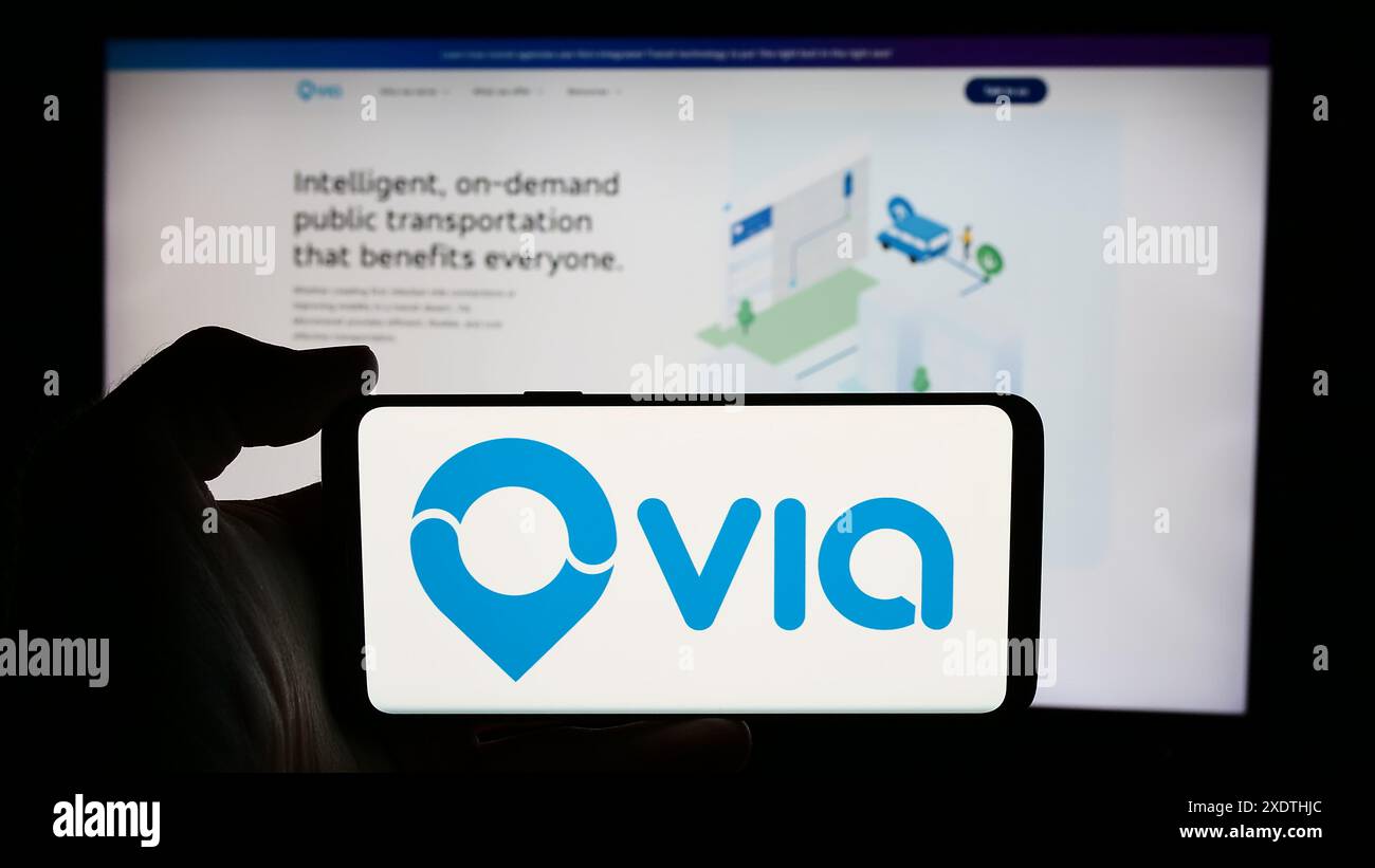 Person holding cellphone with logo of US mobility company Via ...