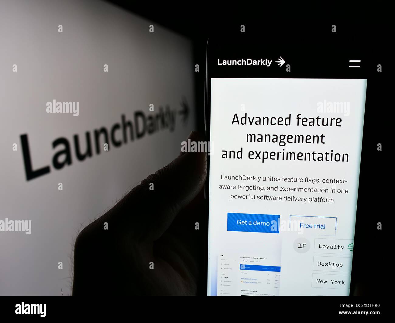 Person holding cellphone with webpage of US software company ...
