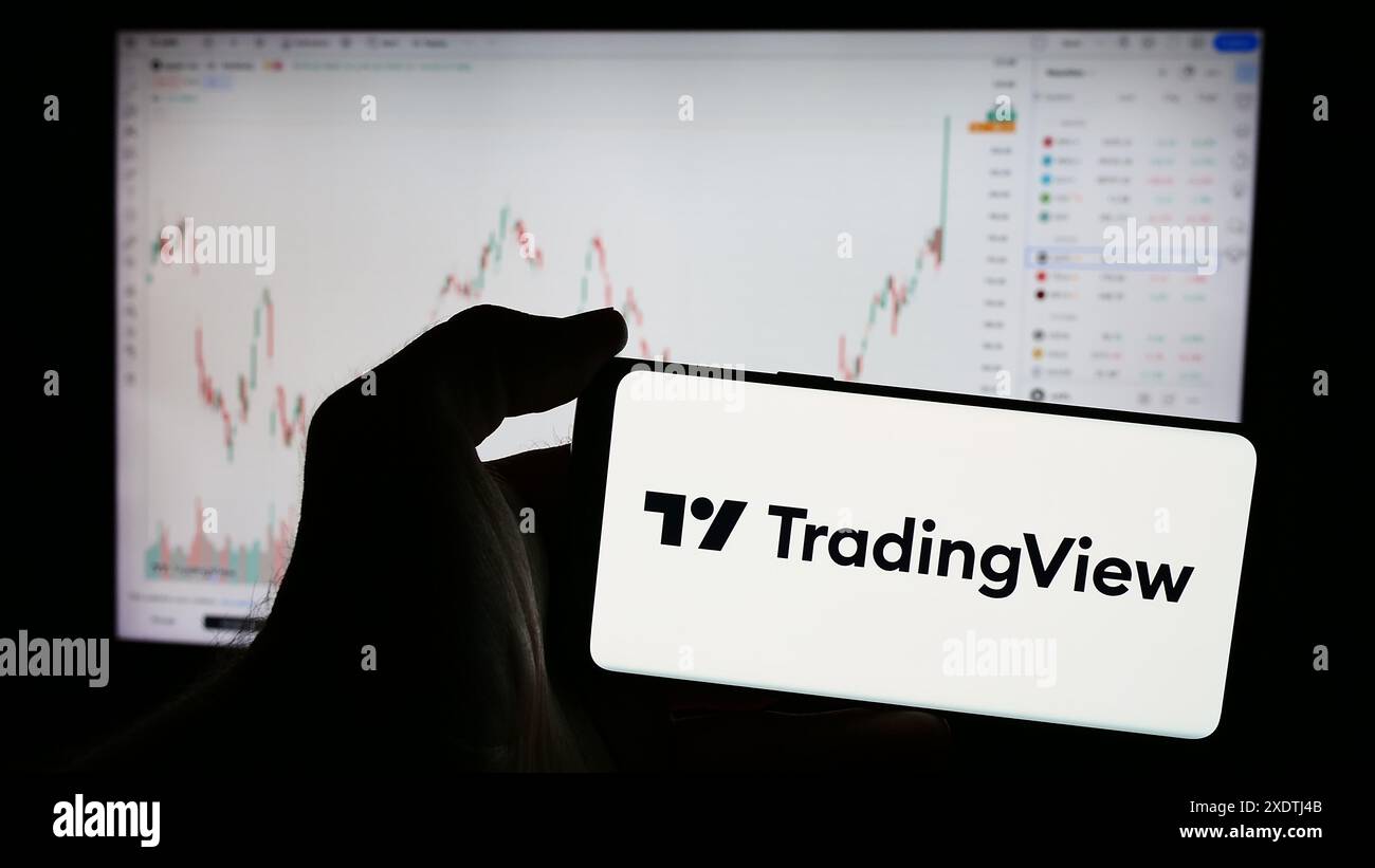 Person holding mobile phone with logo of American trader social network ...