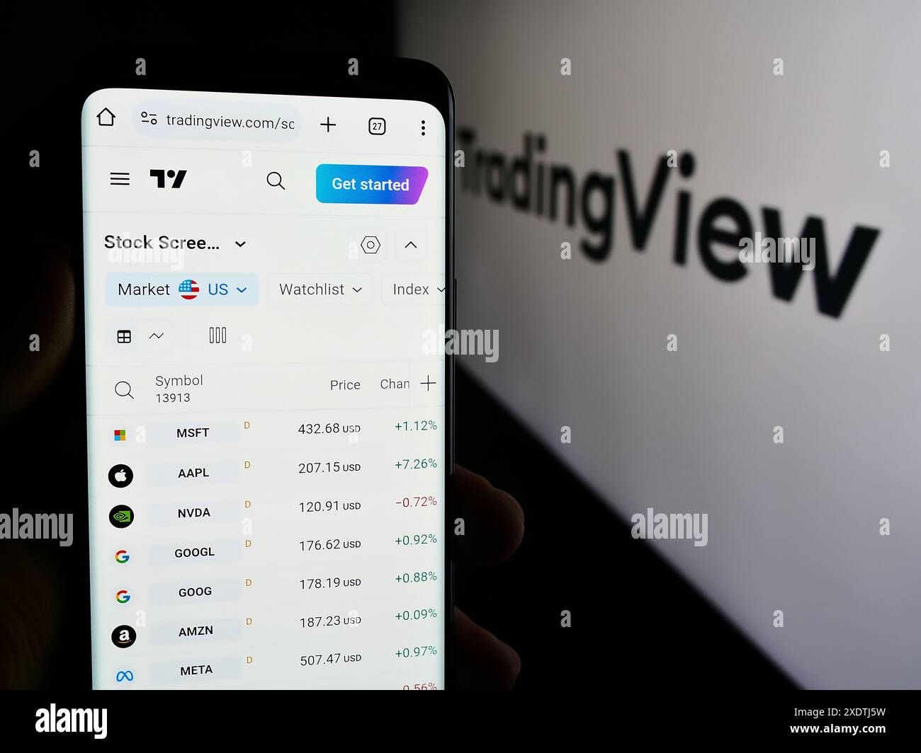 Person holding mobile phone with web page of US trader social network ...