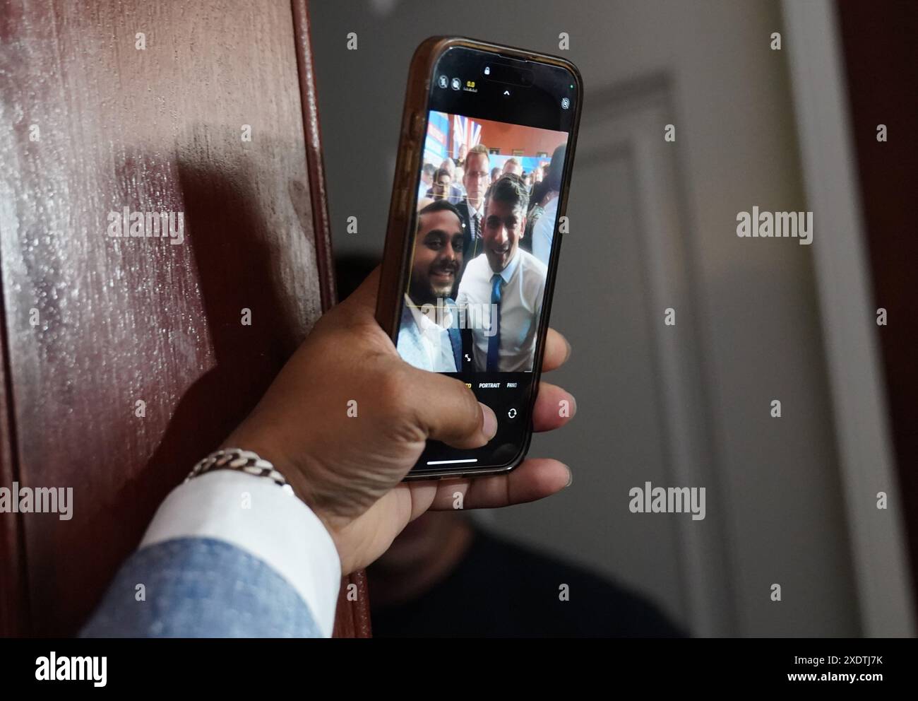 Prime Minister Rishi Sunak appears on the phone screen of the member of ...