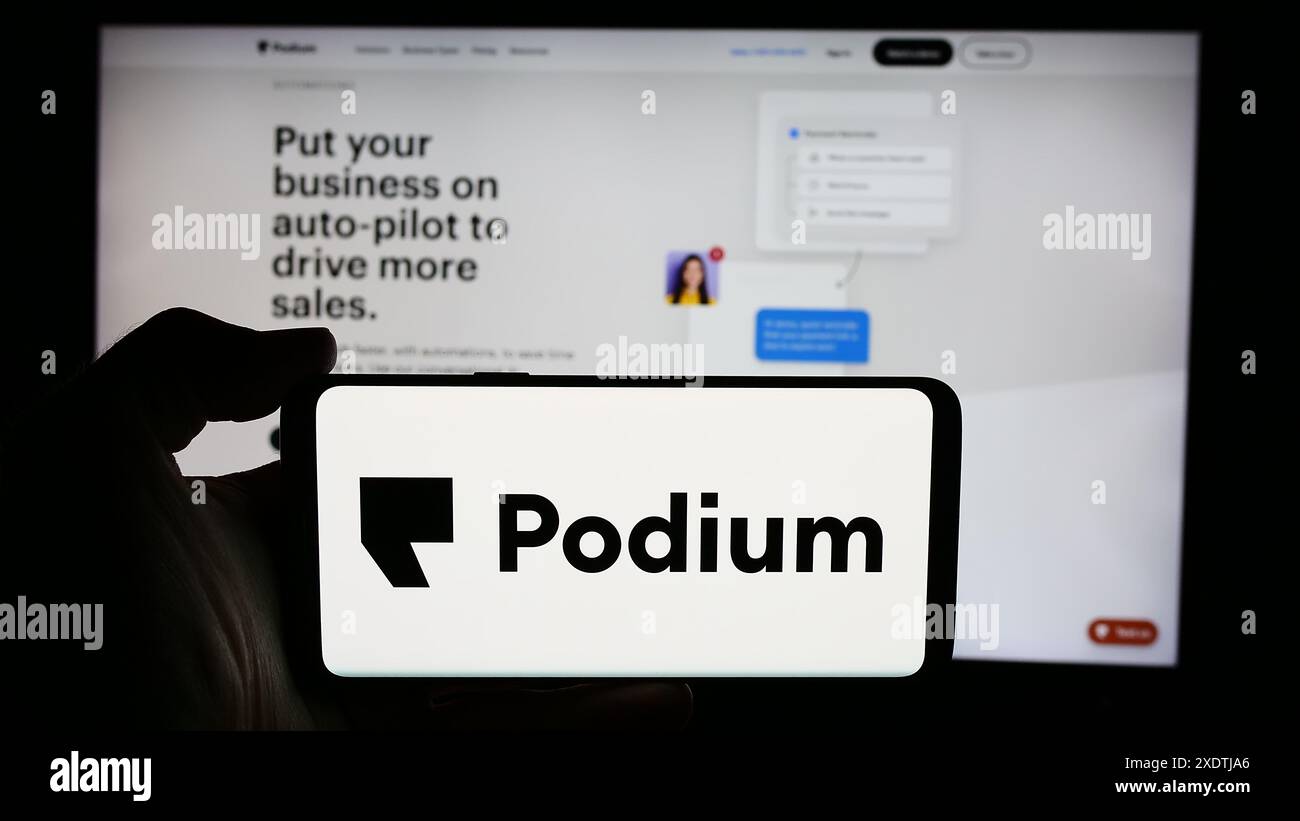Person holding cellphone with logo of US software company Podium ...