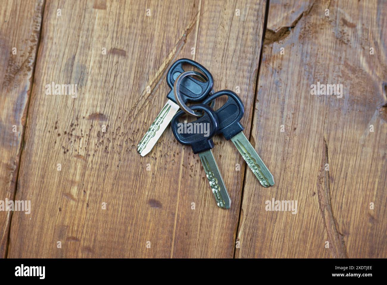 High security key with black insulator on a rustic wooden background ...