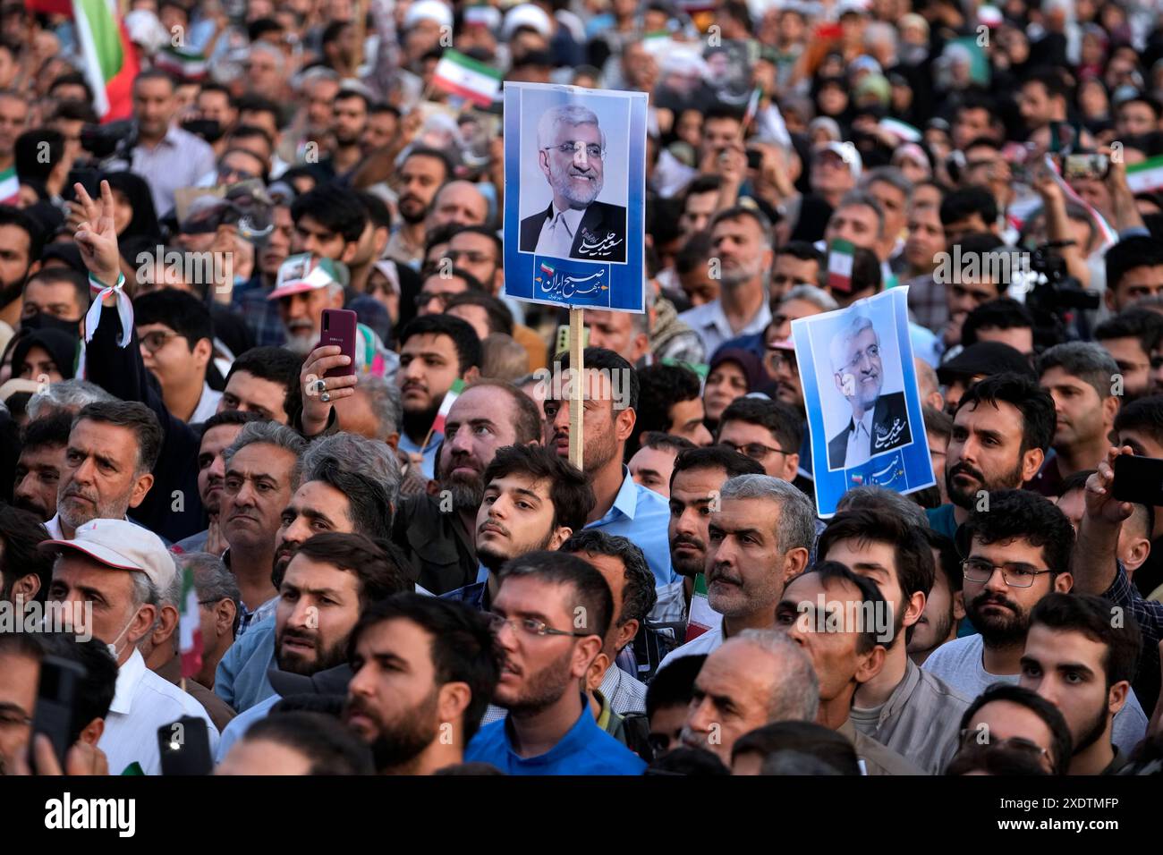Supporters of Saeed Jalili, a candidate for the June 28, presidential election, hold up his ...