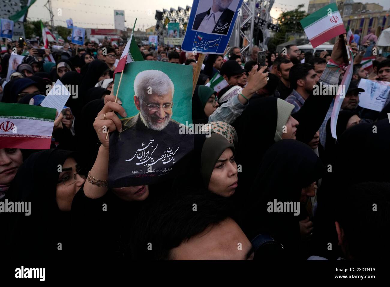 Supporters of Saeed Jalili, shown in the poster, a candidate for the June 28, presidential ...