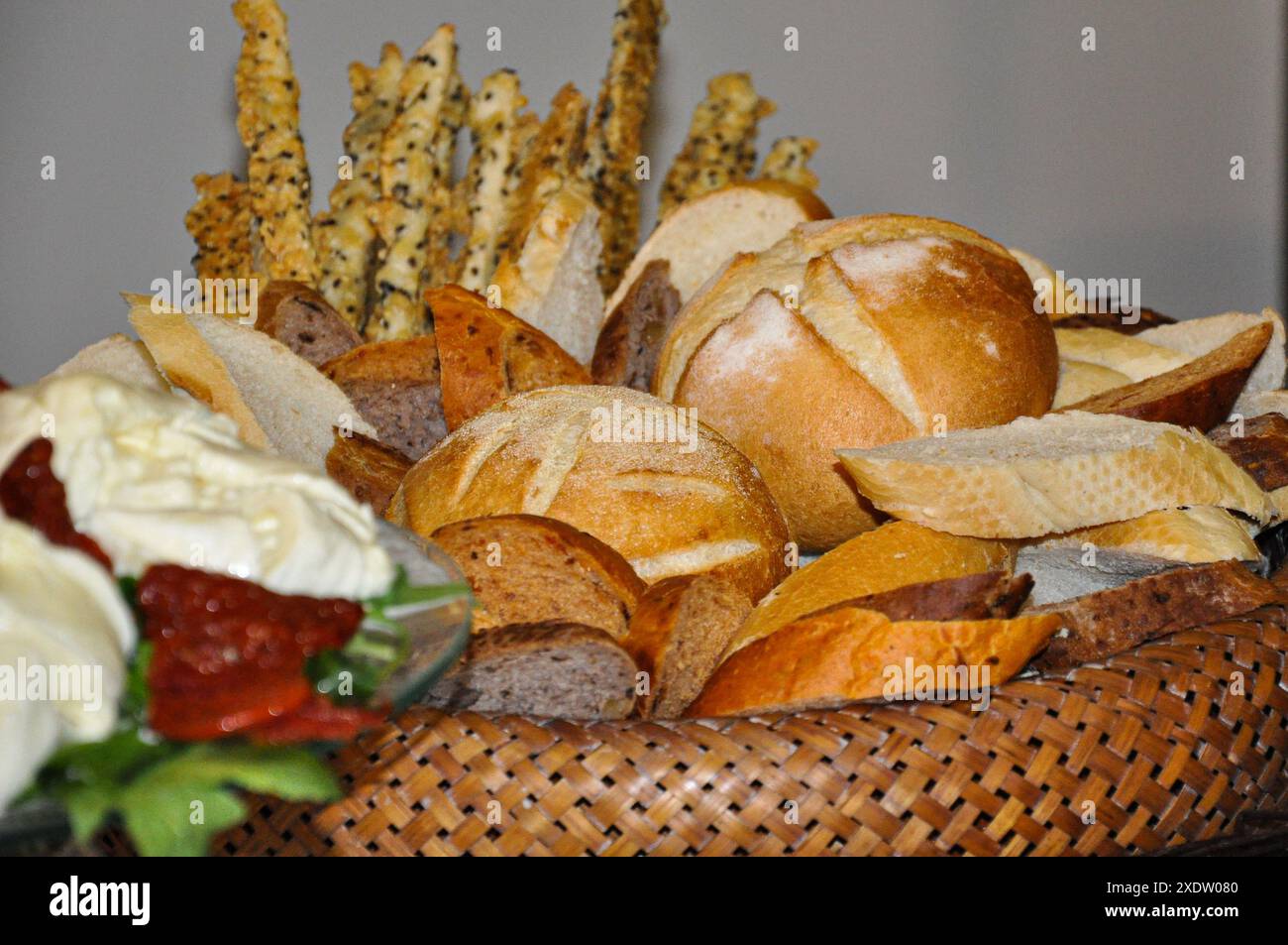 Wicker basket filled with delicious bread of different types: baguette ...