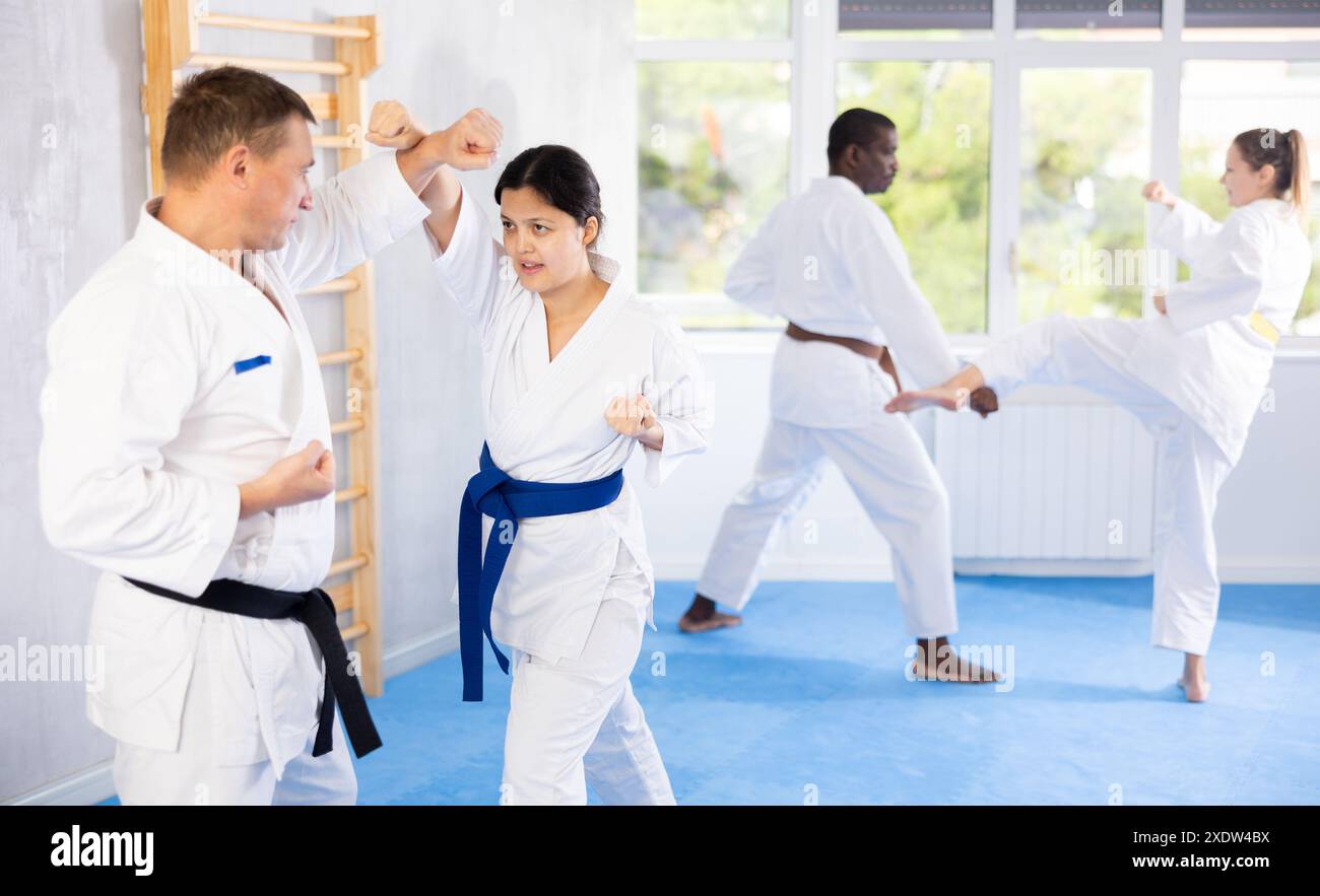 Middle-aged woman attendee of karate classes fighting with her opponent ...
