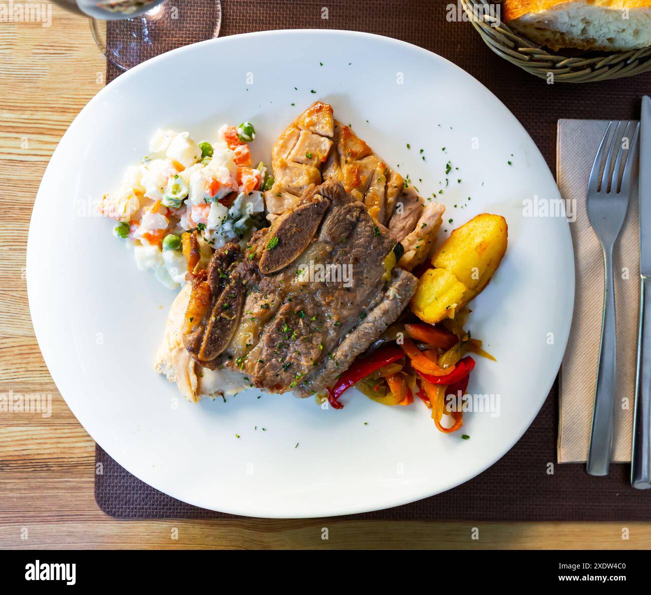 Grilled various meat served with stewed red peppers and salad Stock ...