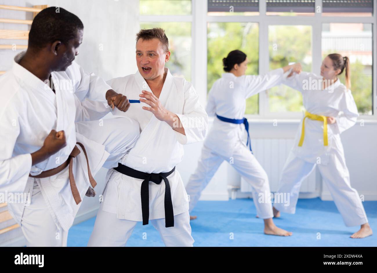 Middle-aged man attendee of karate classes fighting with his opponent ...
