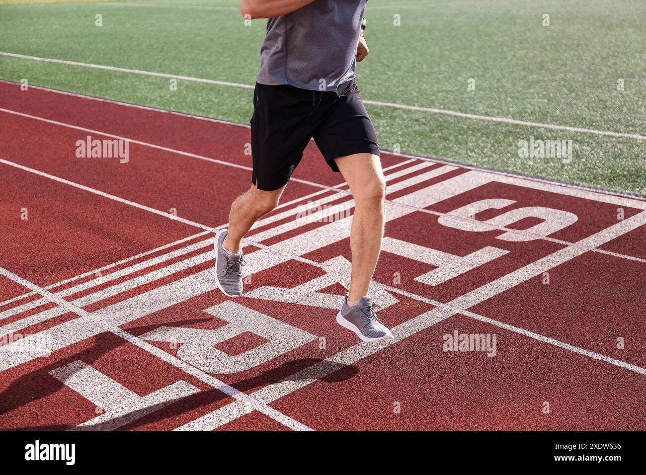 Sporty man running at stadium Stock Photo - Alamy