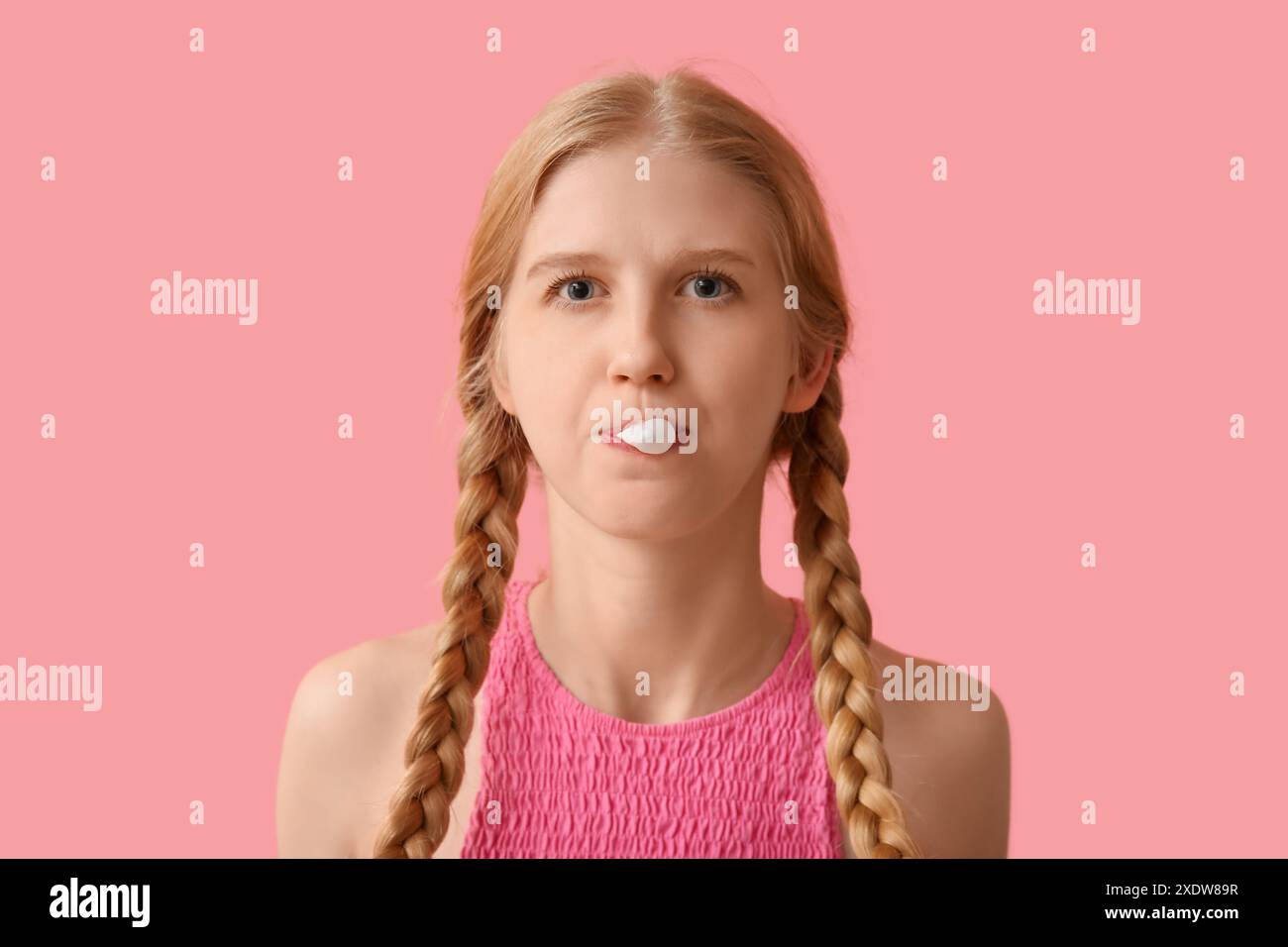 Teenage girl chewing gum on pink background Stock Photo - Alamy