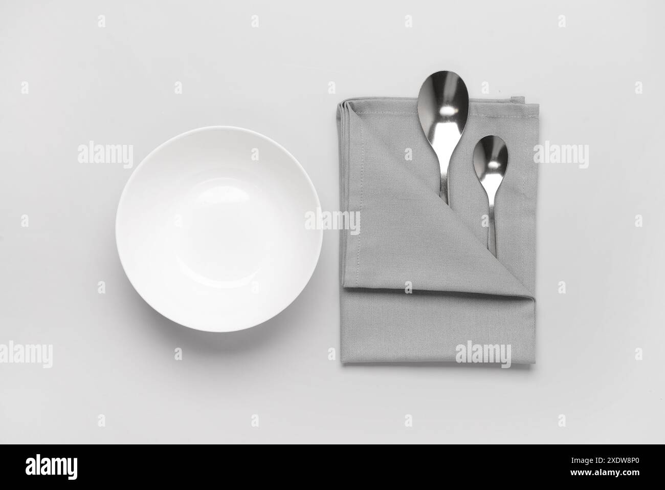 Simple table setting with napkin on white background Stock Photo - Alamy