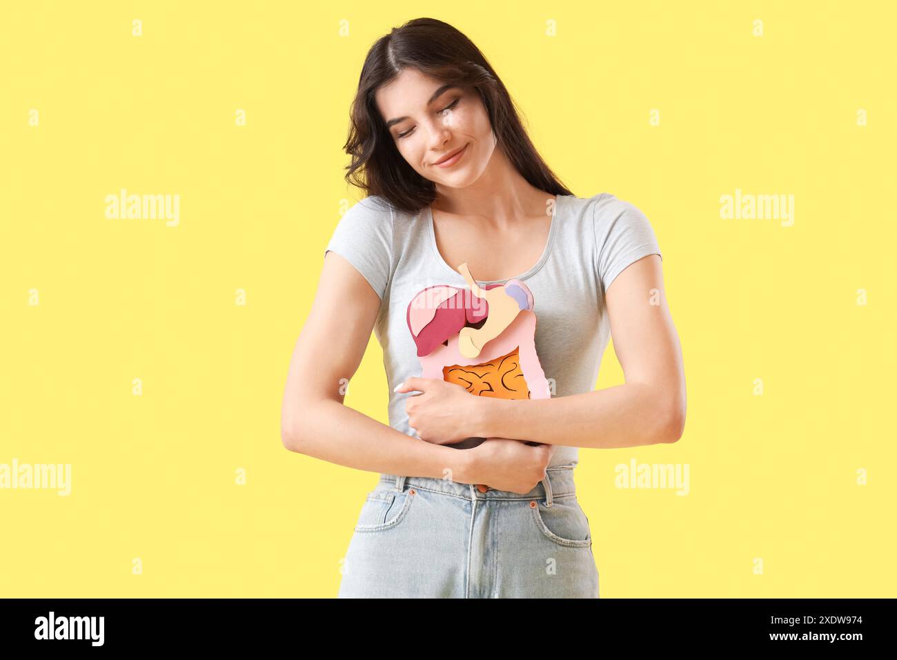 Young woman with paper digestive system on yellow background Stock ...