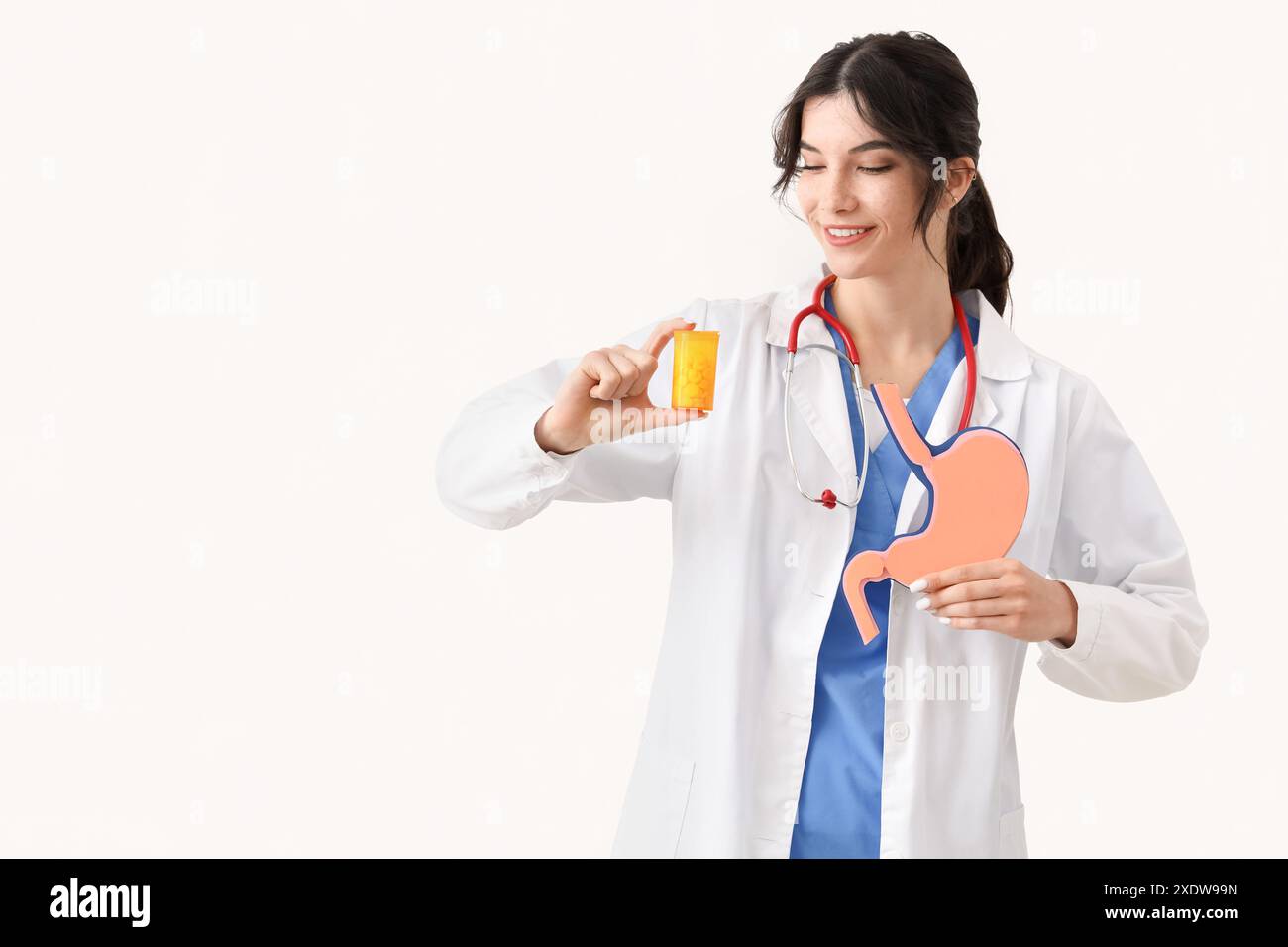 Female doctor with paper stomach and pills on white background Stock ...