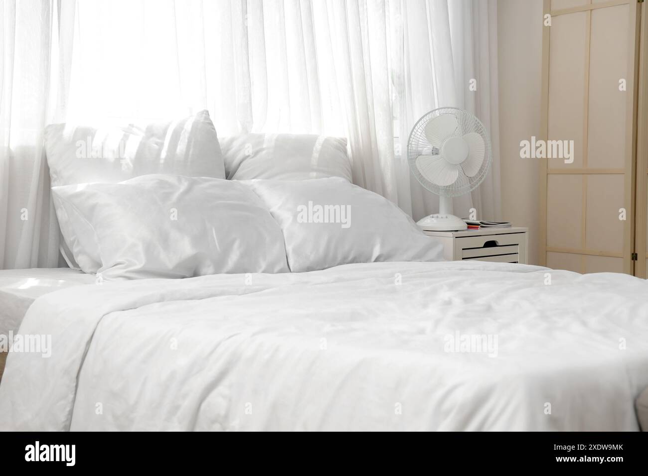 Electric fan on bedside table in bedroom Stock Photo - Alamy