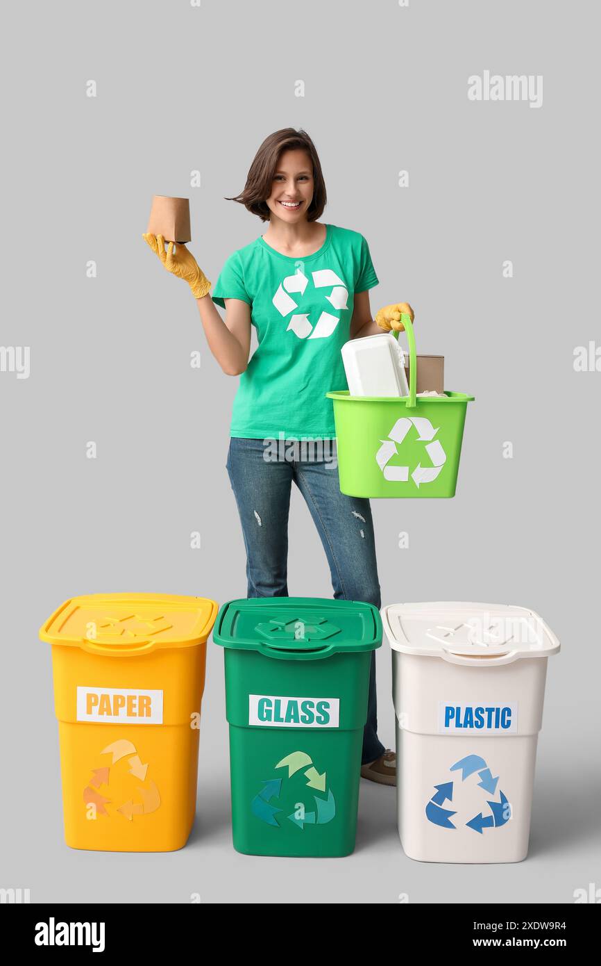 Female volunteer with recycle bins sorting trash on white background ...