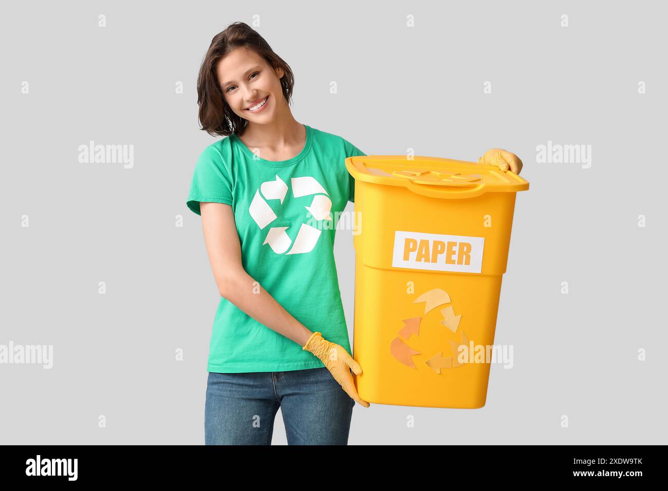 Female volunteer holding recycle bin for paper garbage on white ...