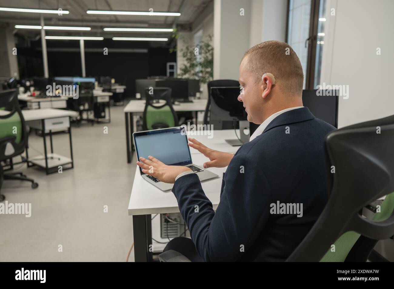 Caucasian deaf man communicates in sign language on laptop in office ...