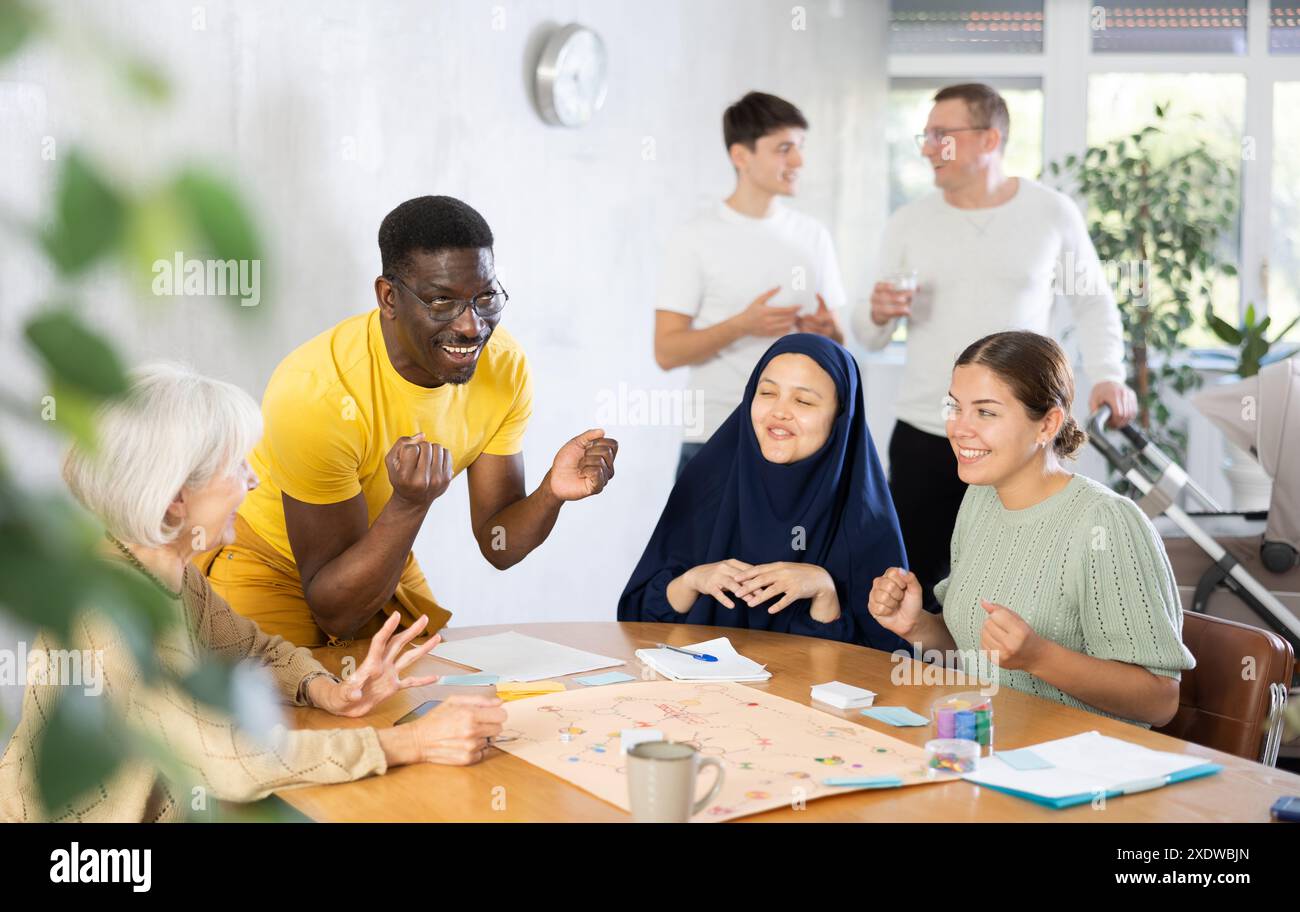 Group of multinational people playing board game Stock Photo - Alamy