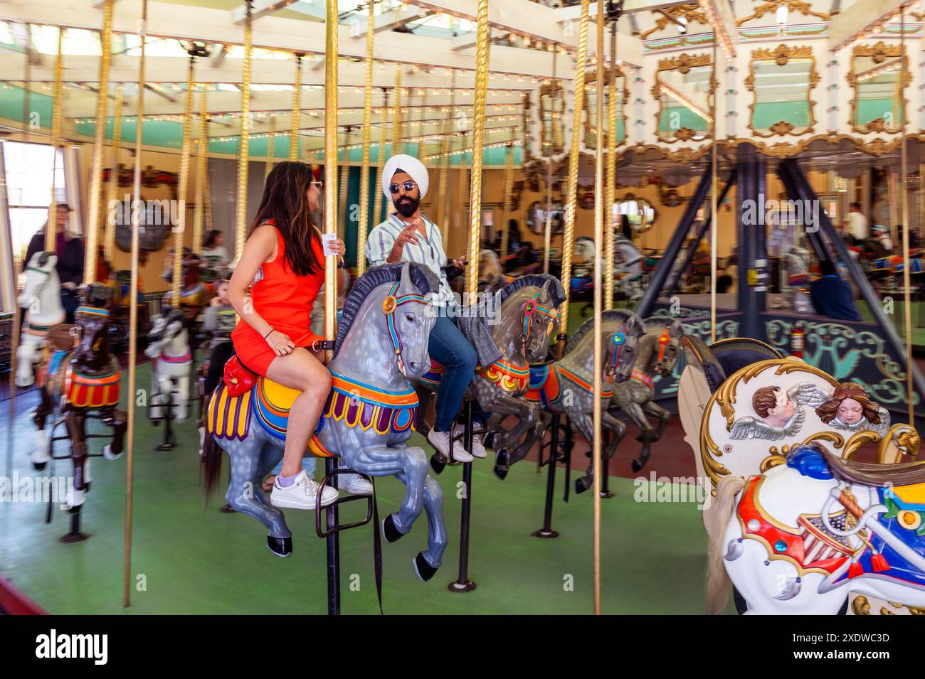 Eastern Indian couple ride the 1911 Looff Carousel; National Historic ...