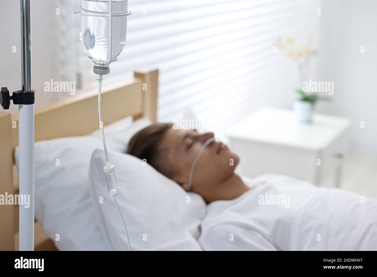 Coma patient. Young man sleeping in hospital bed Stock Photo - Alamy