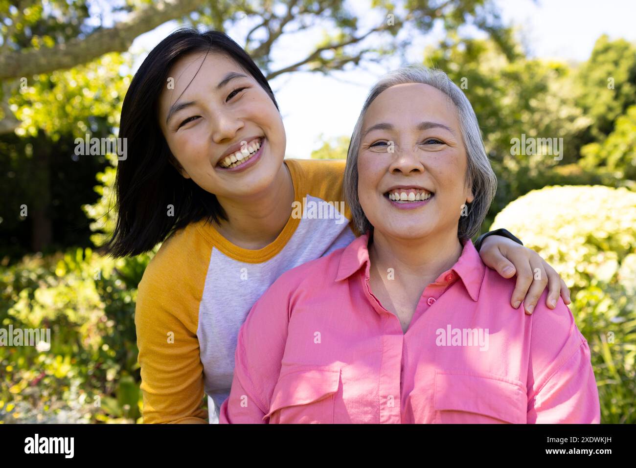 Mother and daughter smiling together outdoors, enjoying quality family ...
