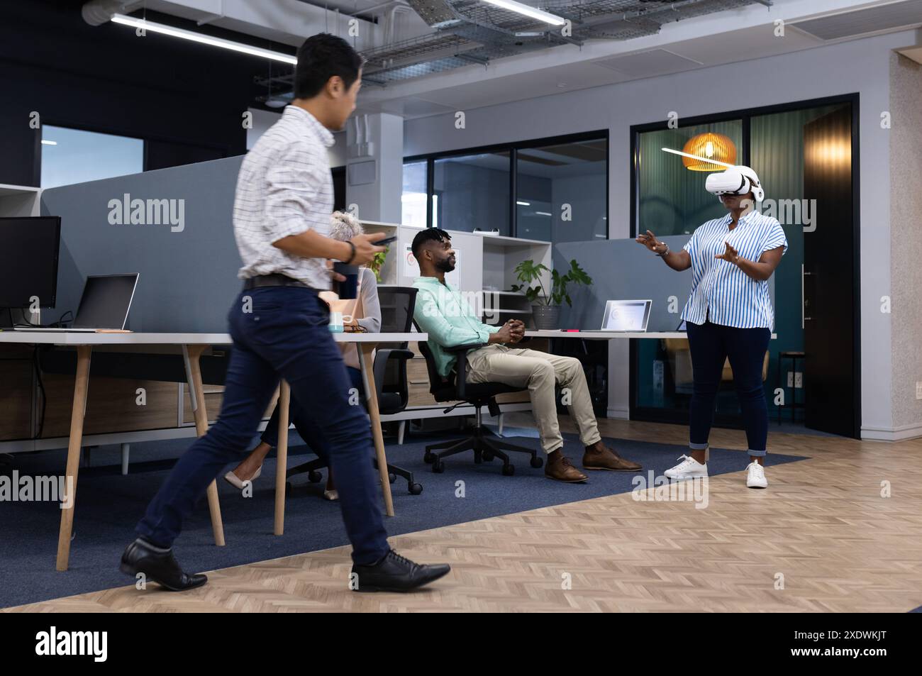 Using VR headset, female office worker demonstrating virtual reality to ...